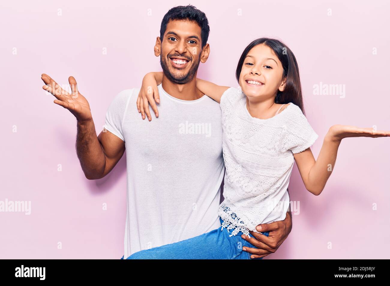 Latin father and daughter wearing casual clothes celebrating ...