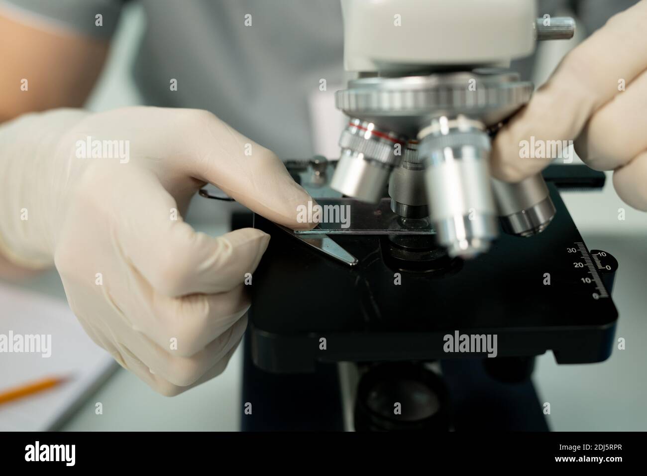 Gloved hand of contemporary worker of scientific laboratory putting ...
