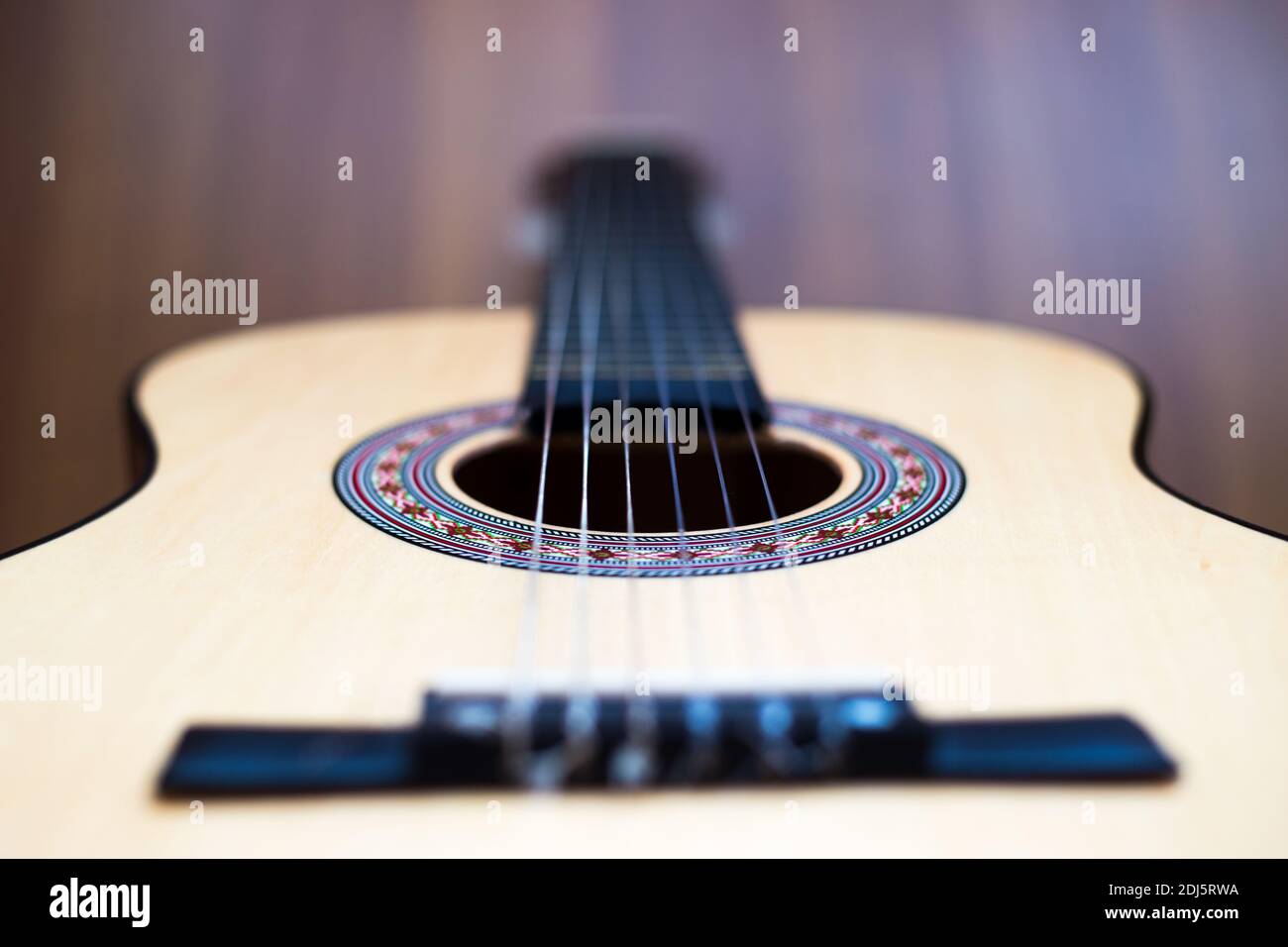 The classical guitar stands on the wooden floor. The classical guitar ...