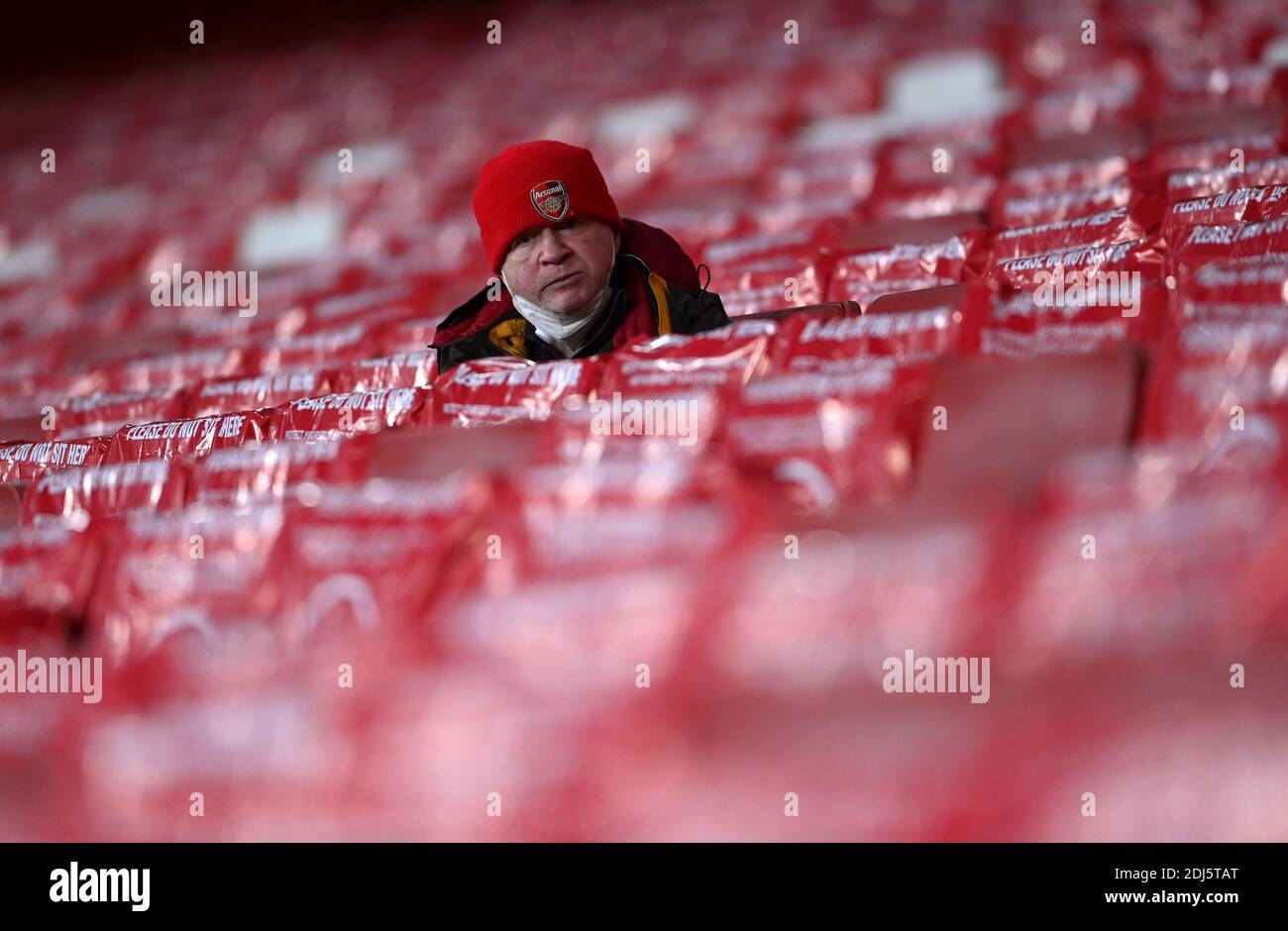 An Arsenal fan takes his seat for the match, before the Premier League ...