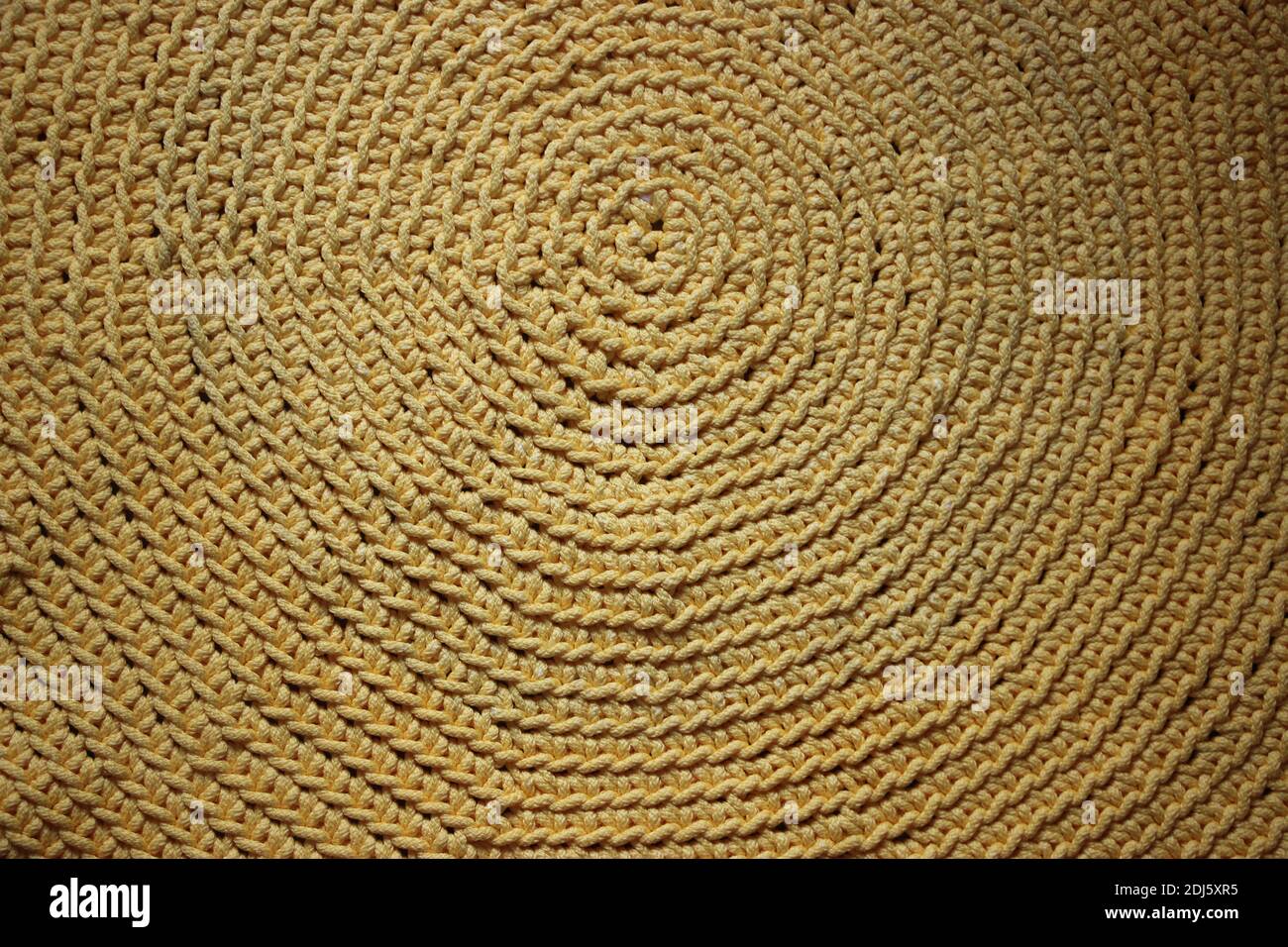 Wrinkled texture of golden yellow crochet handmade rug made of cotton ...