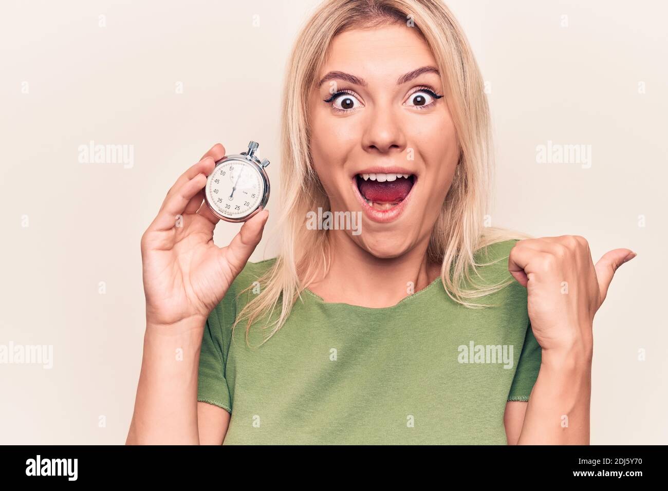 Young beautiful blonde woman doing countdown using stopwatch over white ...