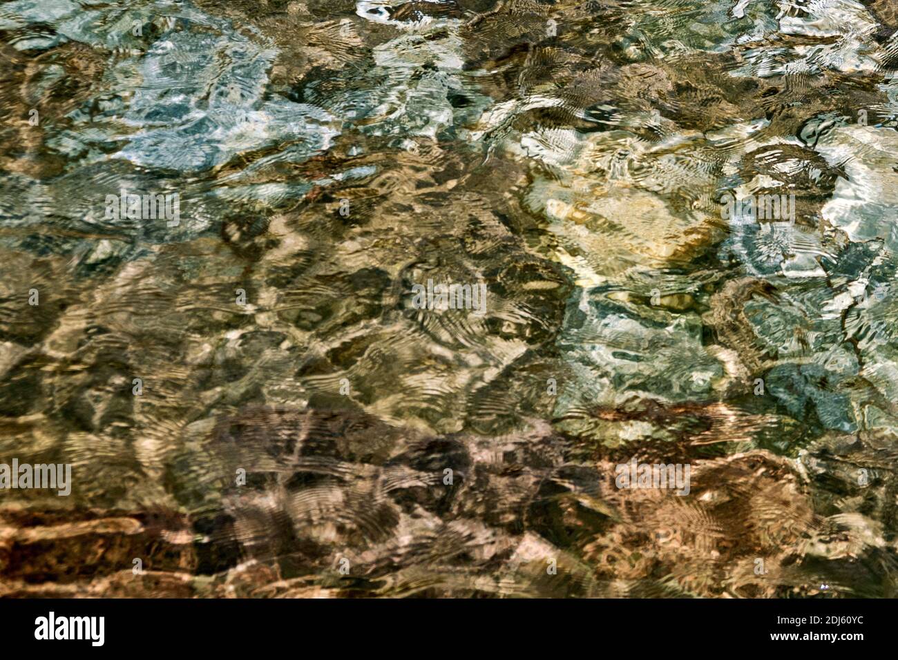 Clear creek water with stones at the bottom. Background of stones ...