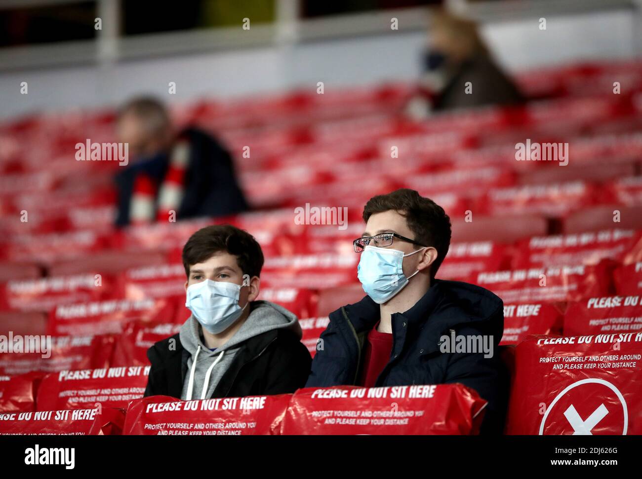 Arsenal fans wearing face masks take their seats before the Premier ...