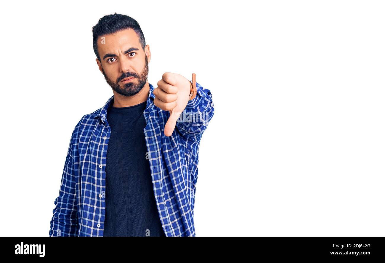 Young hispanic man wearing casual clothes looking unhappy and angry ...