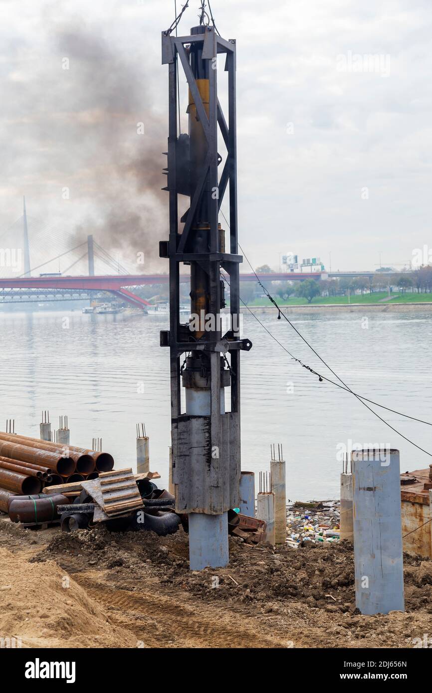 Pipe piles being driven into the ground. Metal pillars foundation ...