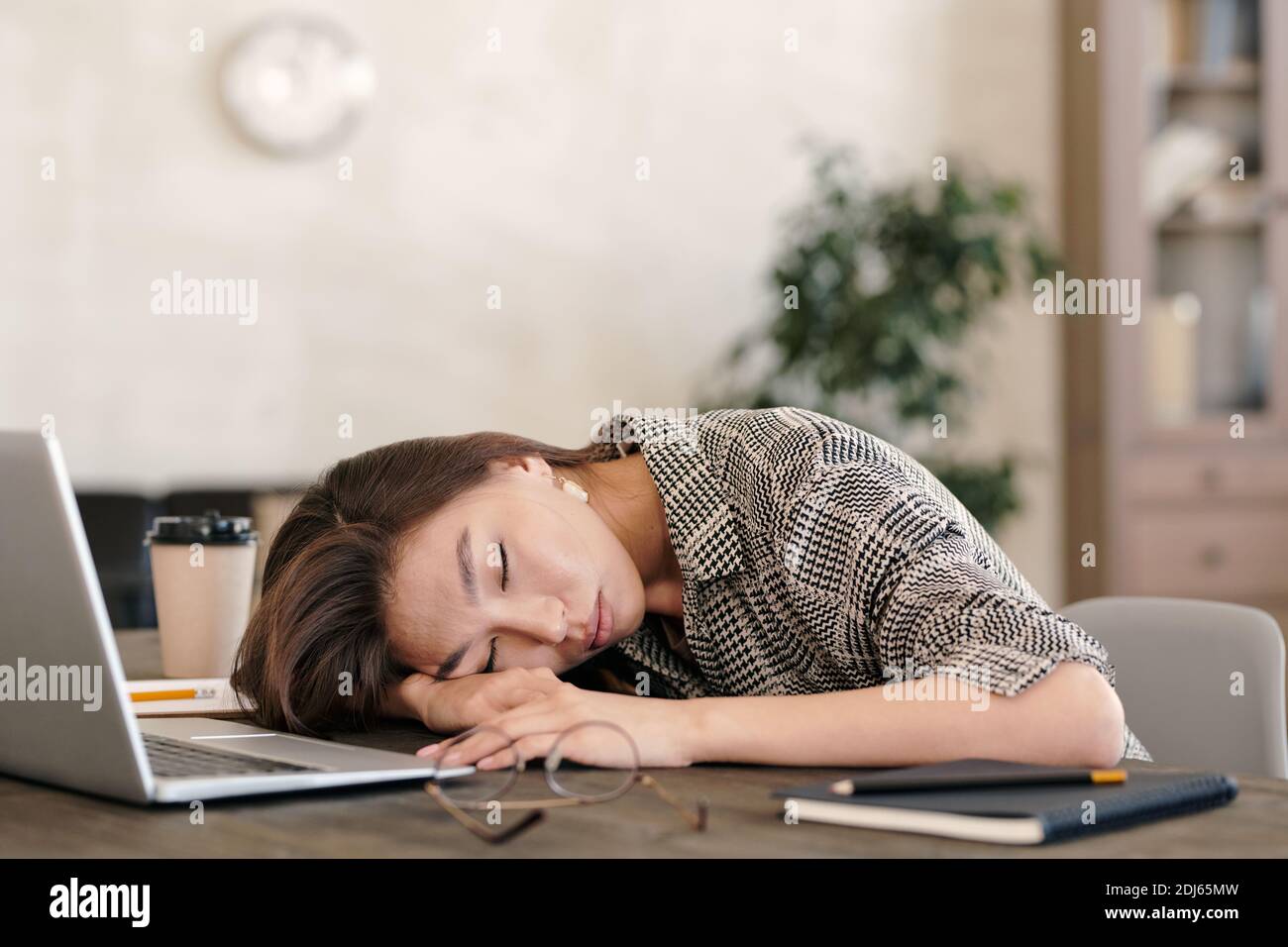 Young exhausted businesswoman in formalwear keeping her head on hand ...