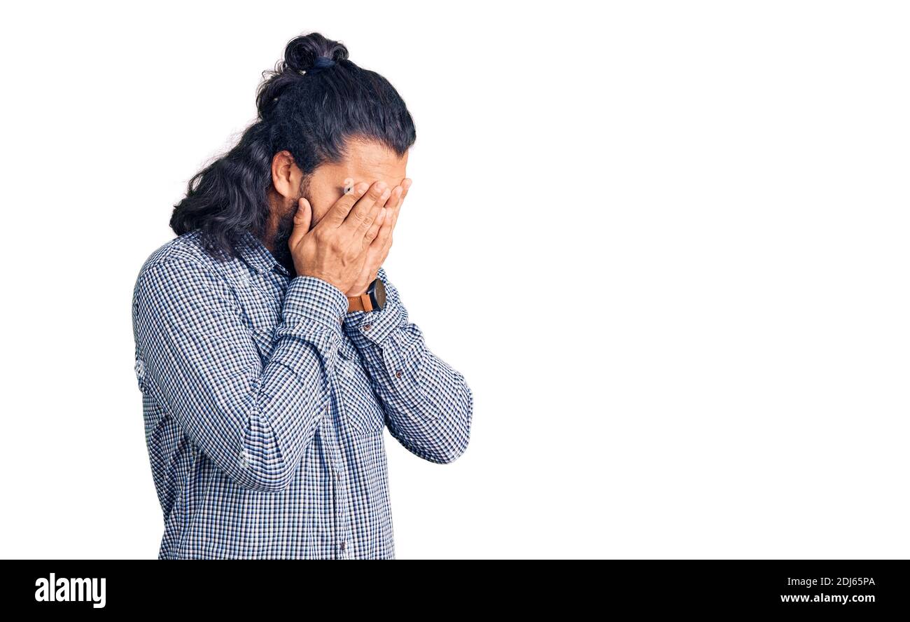 Young arab man wearing casual clothes with sad expression covering face ...