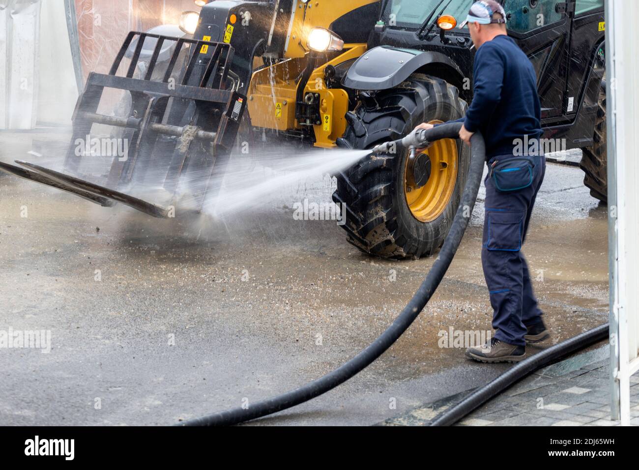 Washing construction machinery off dirt before goes out of the ...