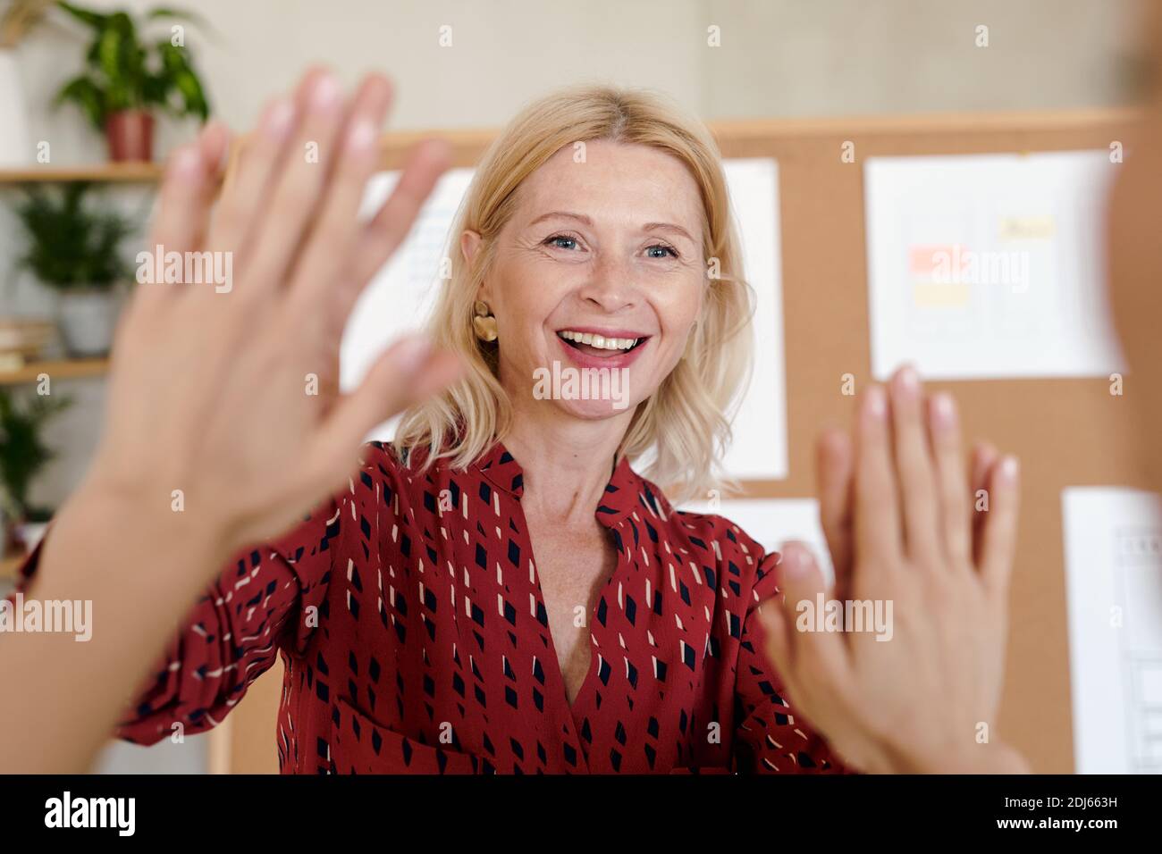 Happy successful mature businesswoman in smart casualwear giving ...