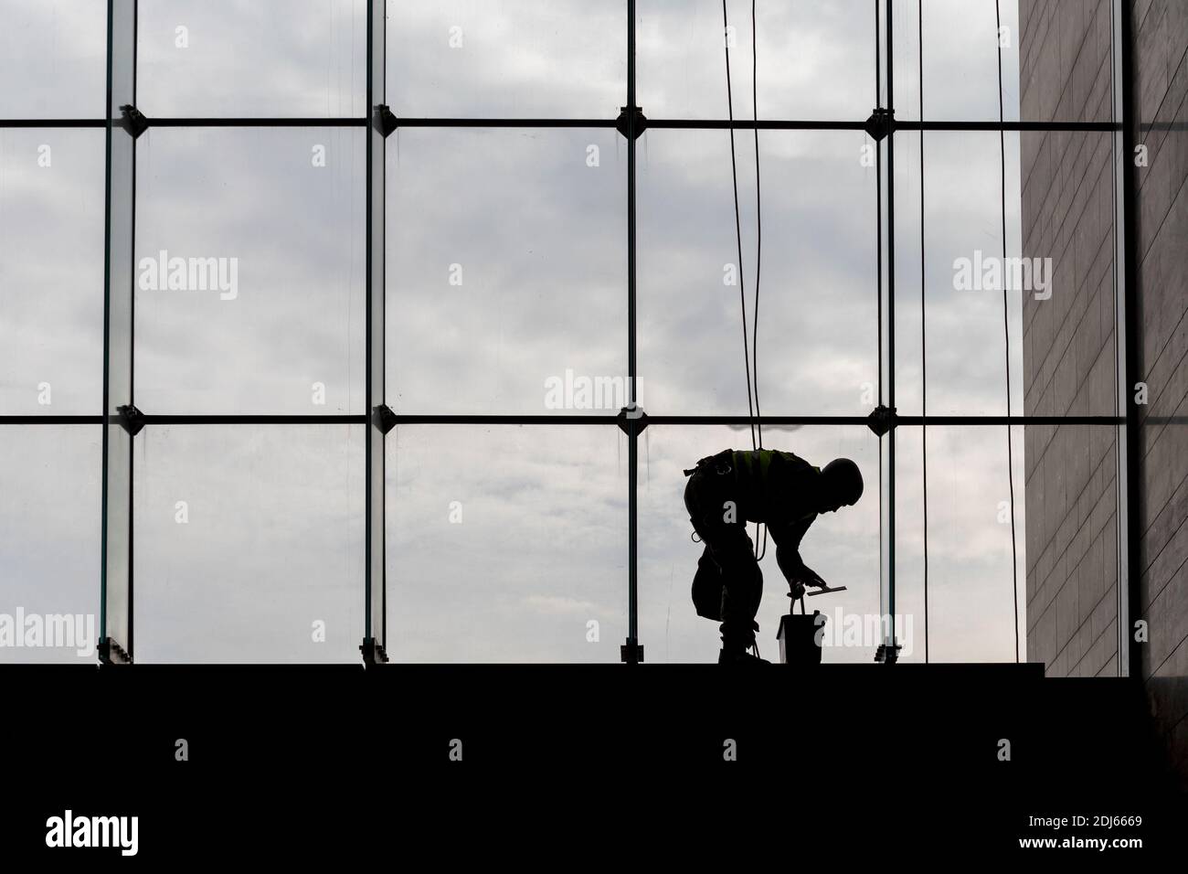 Worker silhouettes cleaning windows from the inside, cleaning building ...