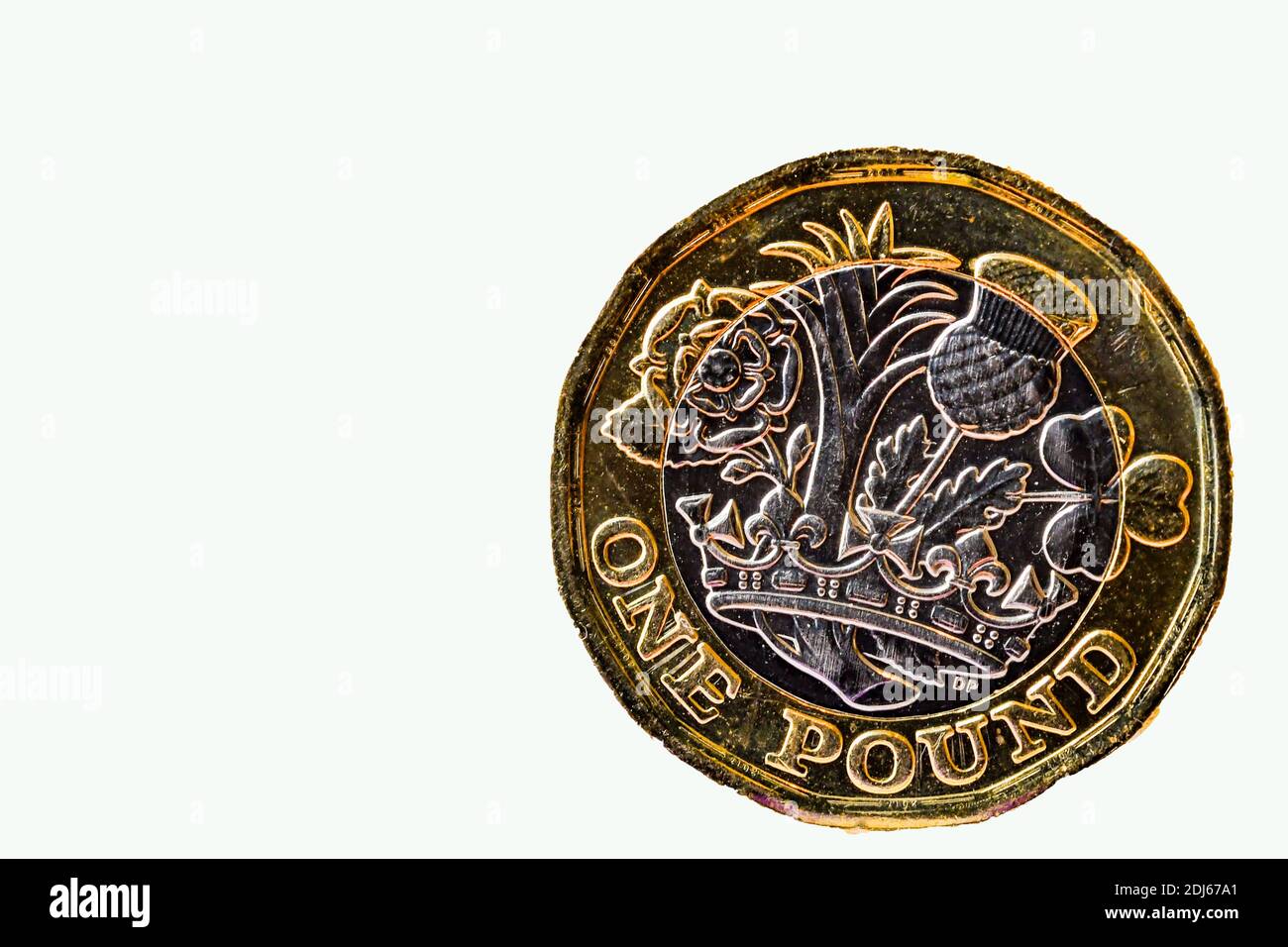 Close up of a one pound coin standing on its edge against a plain white ...