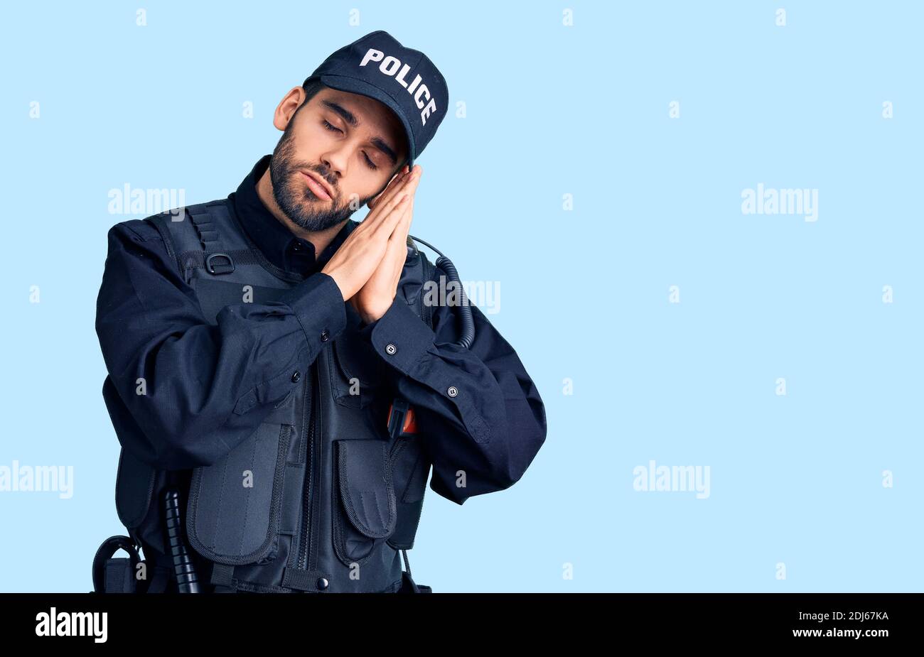 Young handsome man with beard wearing police uniform sleeping tired ...