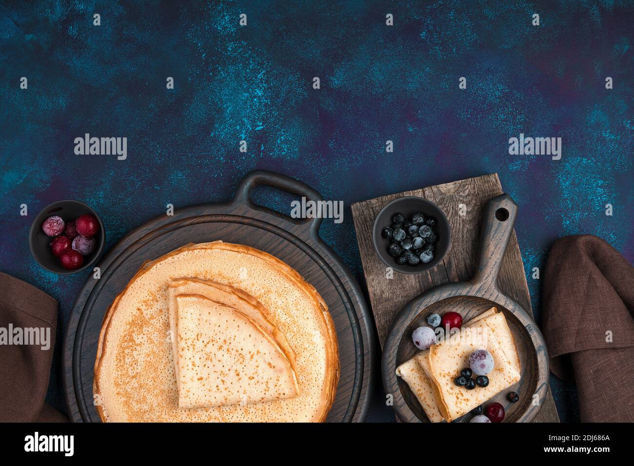 Pancakes on brown wooden trays on a blue background Stock Photo - Alamy