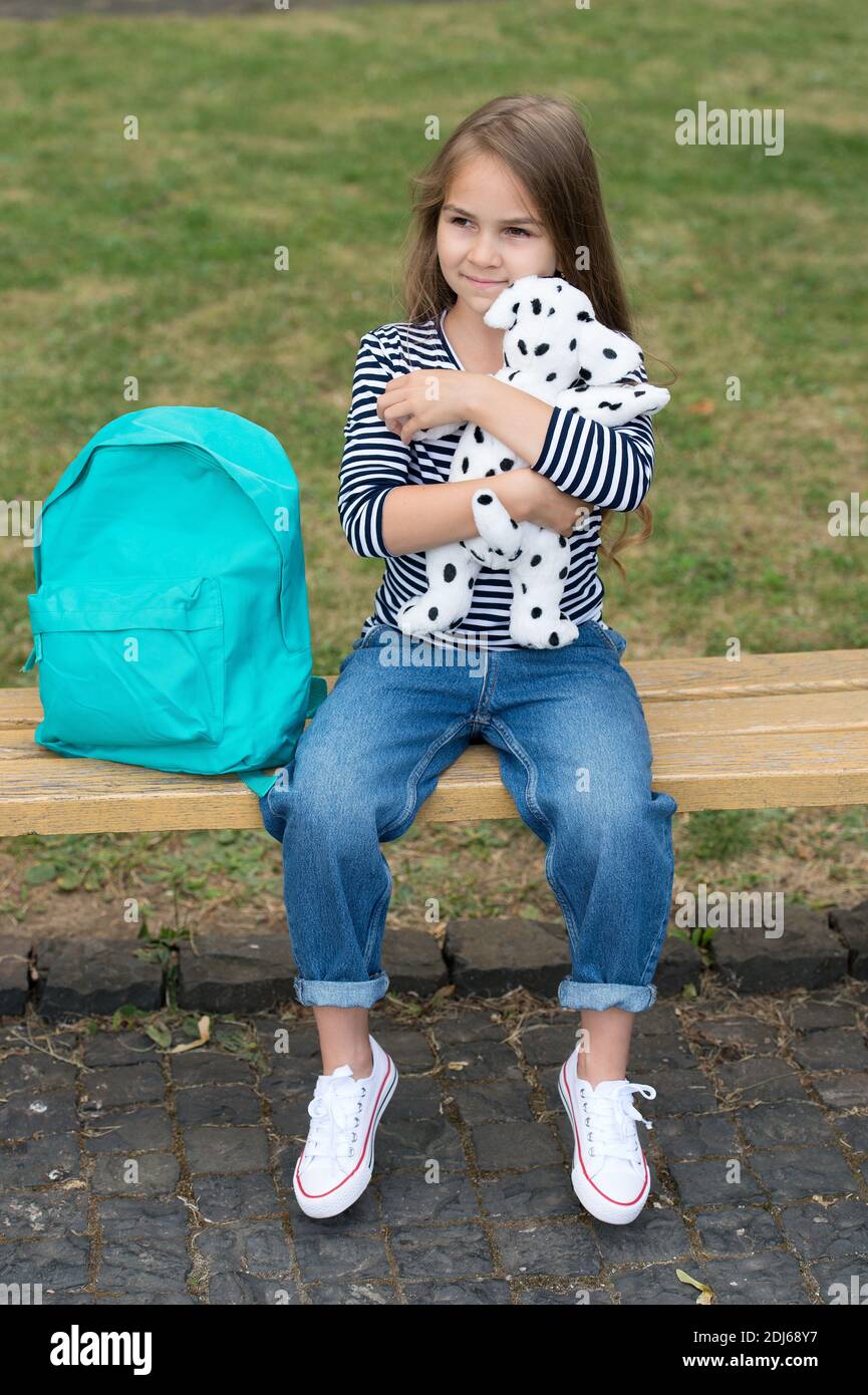 Biggest joy is playing. Happy kid play with toy dog outdoors. Childhood ...