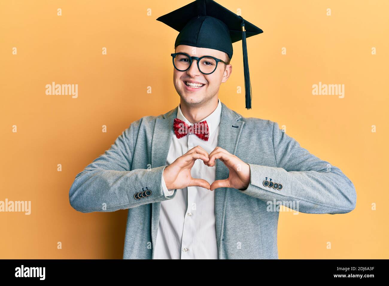 Young caucasian nerd man wearing glasses and graduation cap smiling in ...