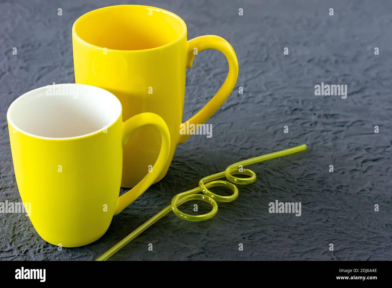 Two yellow cups on gray background. Color of the year 2021 Stock Photo ...