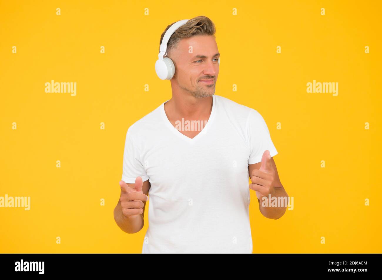 Happy Middle Aged Man Listen To Music In Modern Headphones Pointing