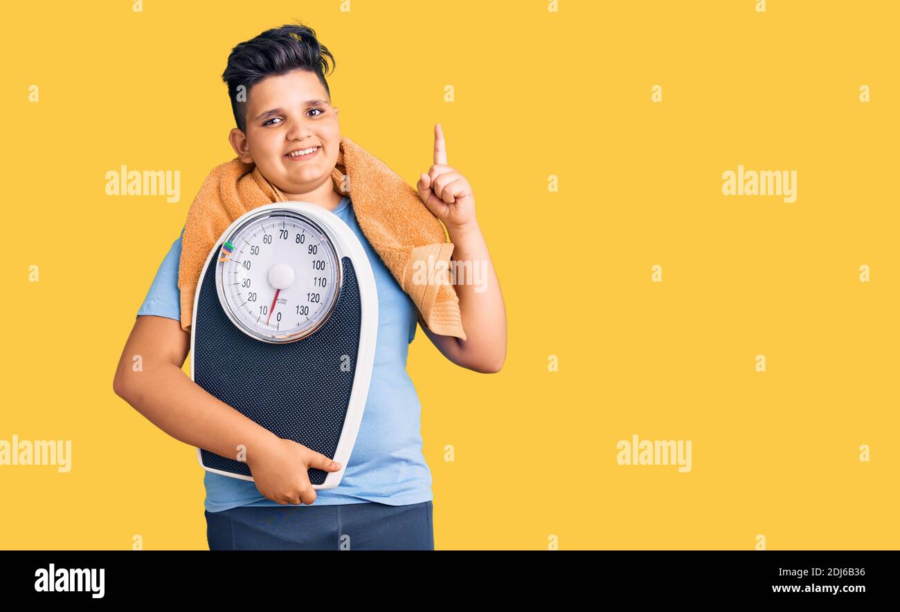 Little boy kid holding weight machine to balance weight loss surprised ...