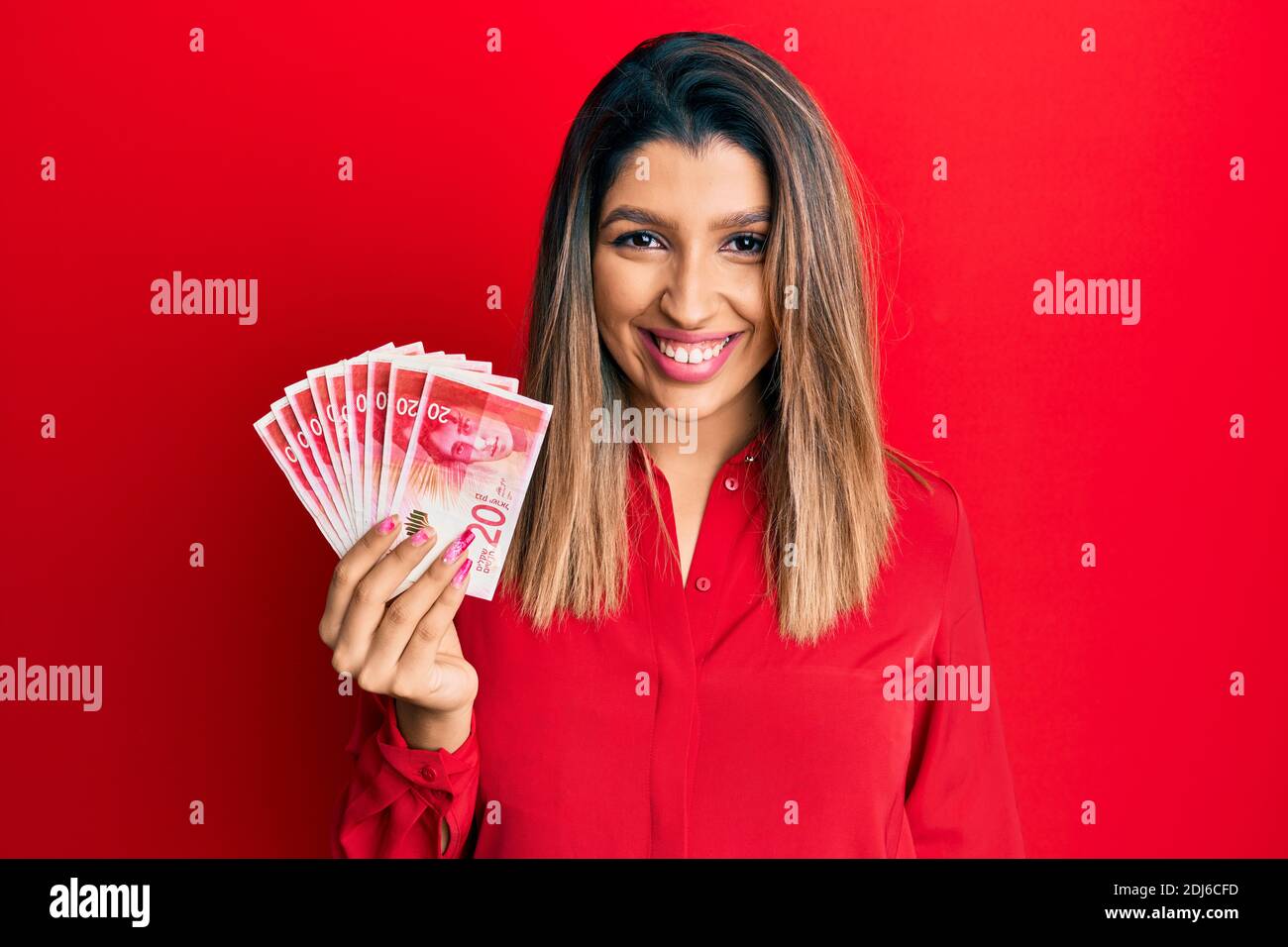 Beautiful brunette woman holding 20 israel shekels banknotes looking ...