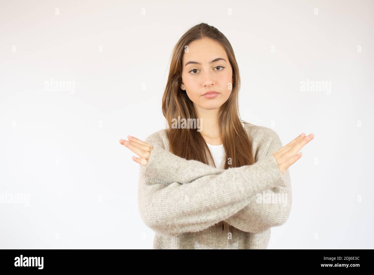 Beautiful young woman showing a stop arms crossed. On a white ...