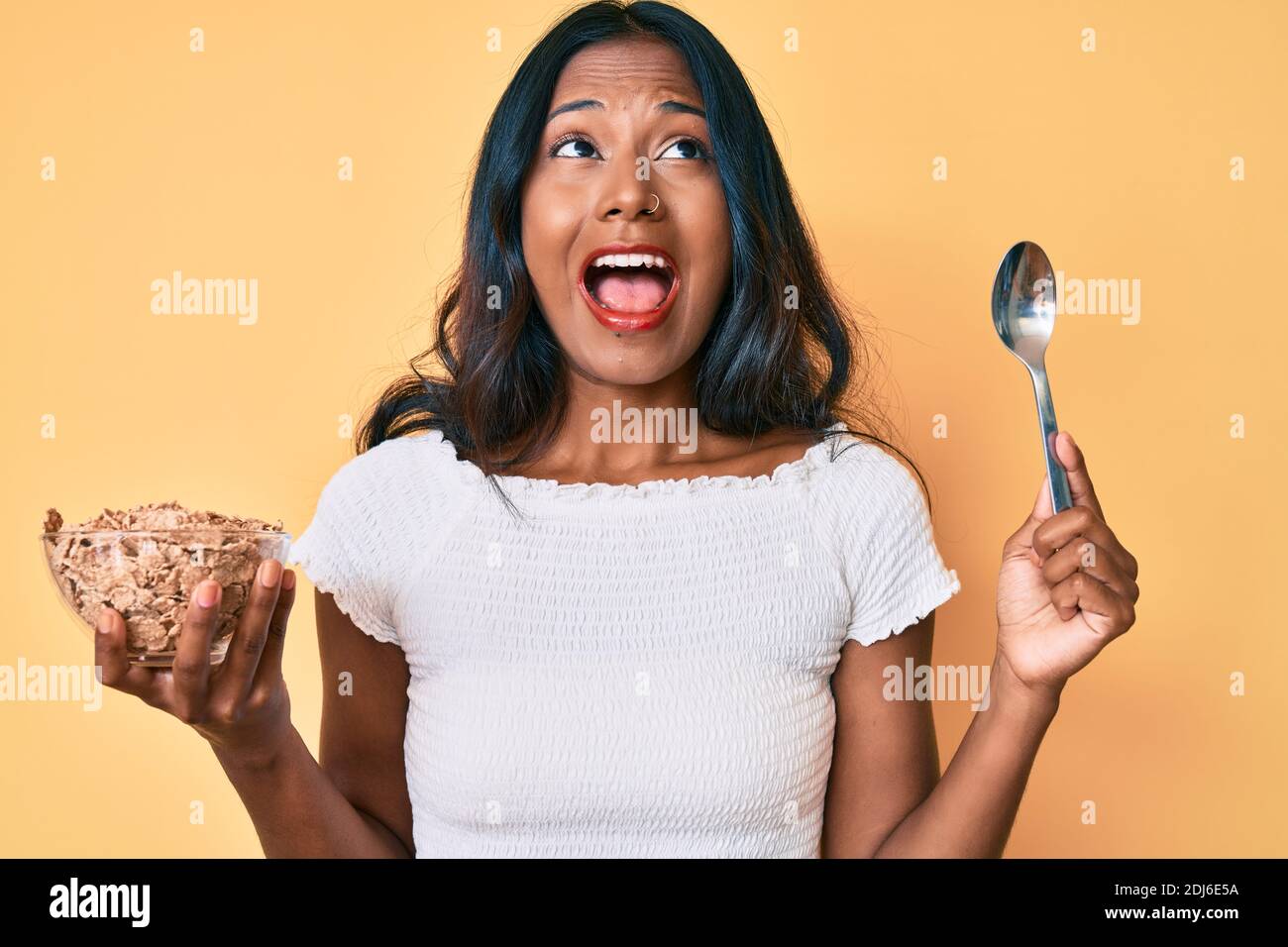 Young indian girl eating healthy whole grain celears angry and mad ...