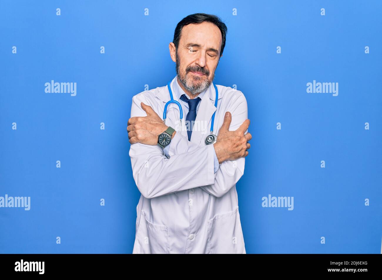 Middle age handsome doctor man wearing coat and stethoscope over ...