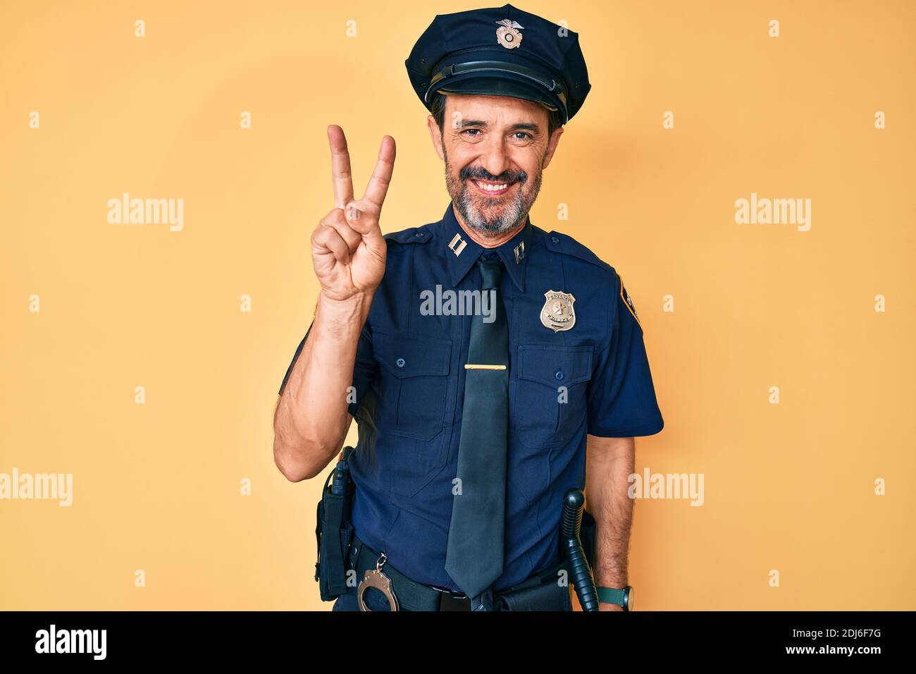 Middle age hispanic man wearing police uniform showing and pointing up ...