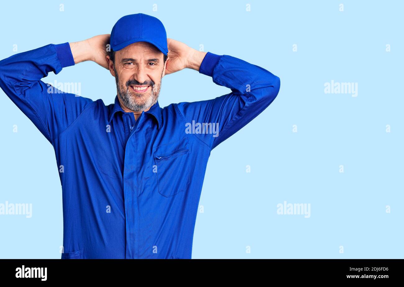 Middle age handsome man wearing mechanic uniform relaxing and ...