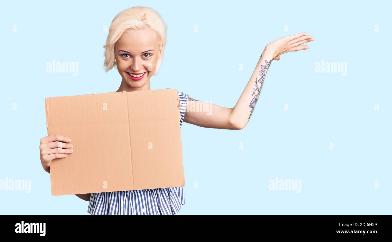 Young blonde woman holding cardboard empty banner celebrating victory ...