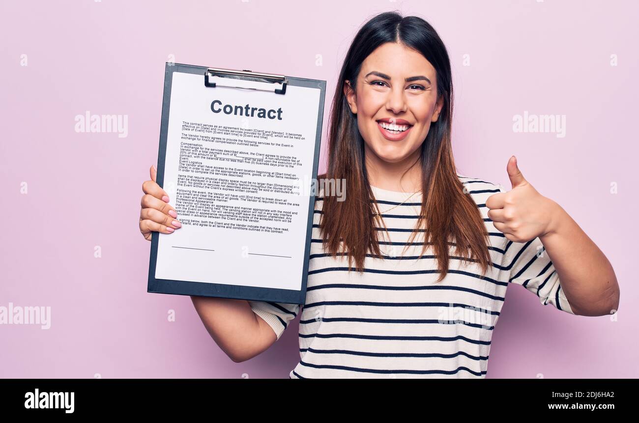 Young beautiful woman holding clipboard with contract document over ...