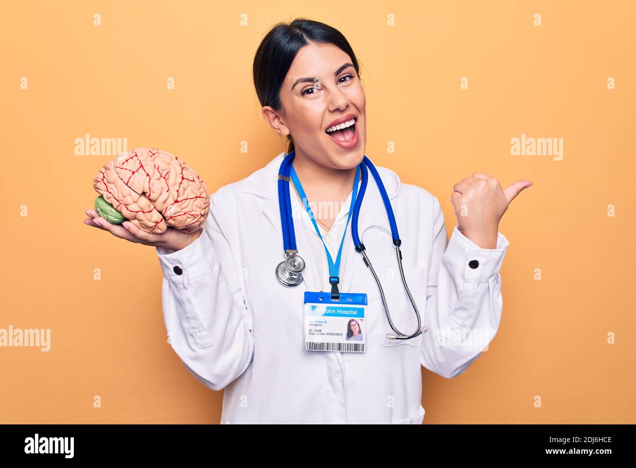 Young beautiful psychiatrist woman wearing stethoscope holding brain ...