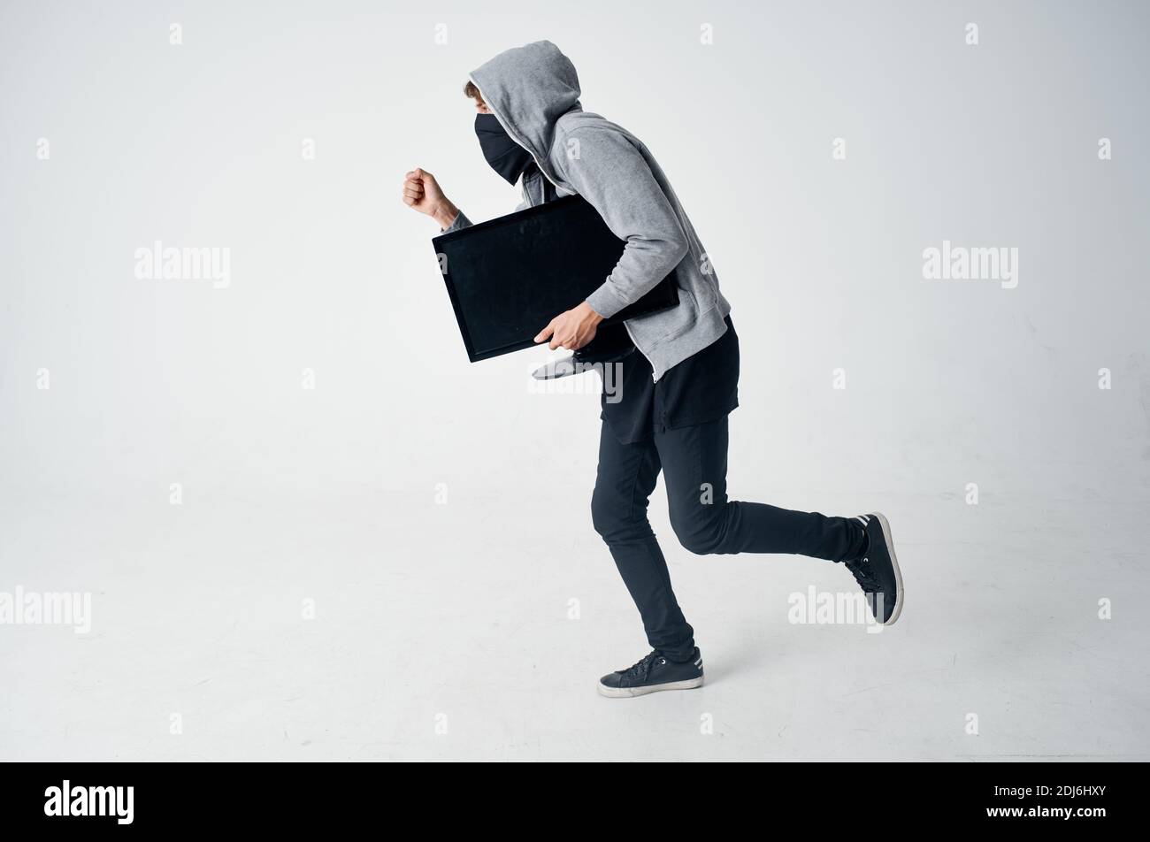 a man in a gray hoodie disguise theft technique hacker Stock Photo - Alamy