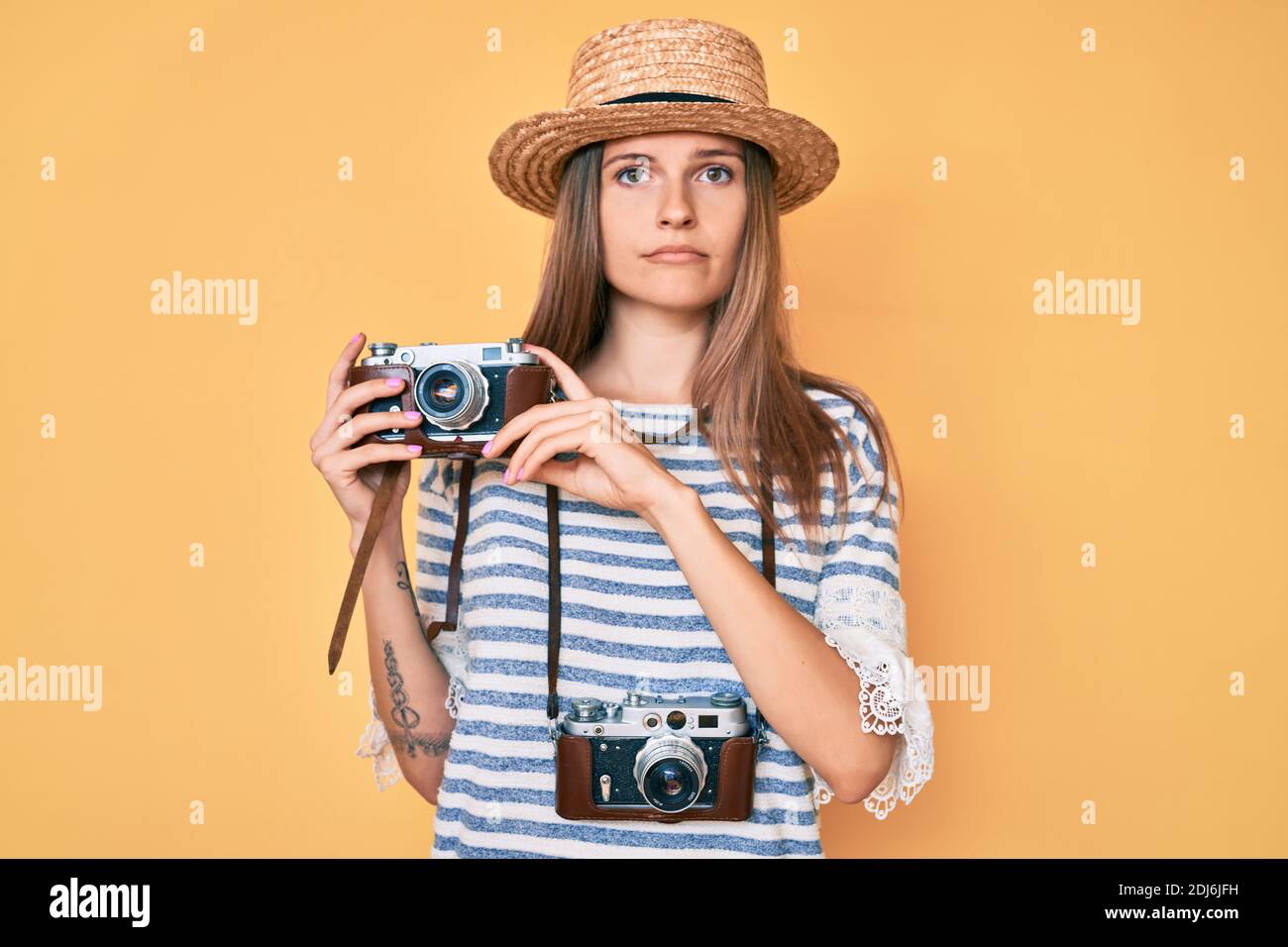 Beautiful caucasian tourist woman holding vintage camera relaxed with ...