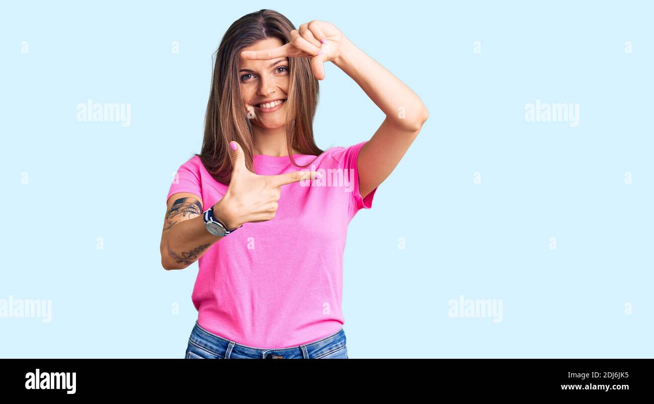 Beautiful caucasian woman wearing casual clothes smiling making frame ...