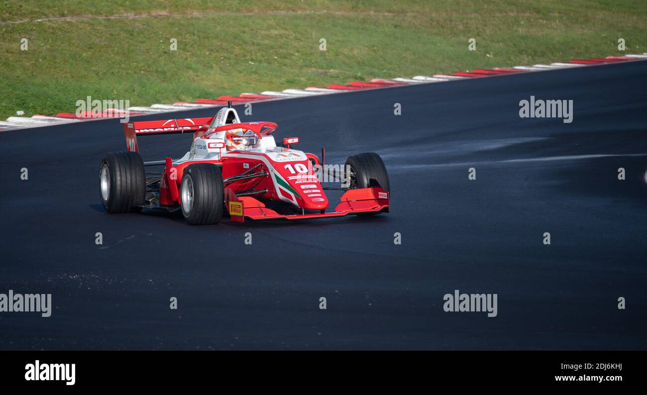 Racing car single seater modern formula in action at turn on wet ...