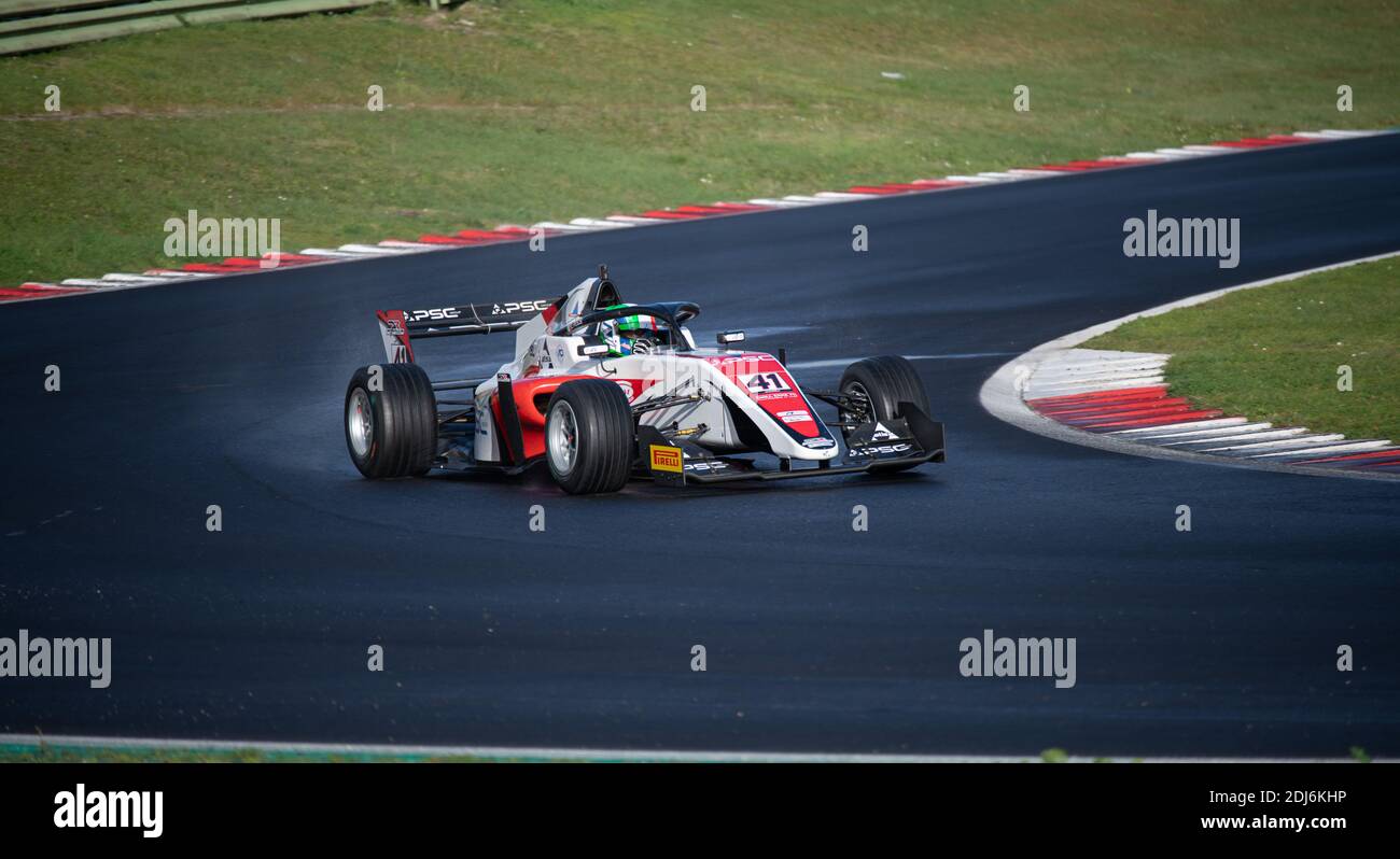 Racing car single seater modern formula in action at turn on wet ...