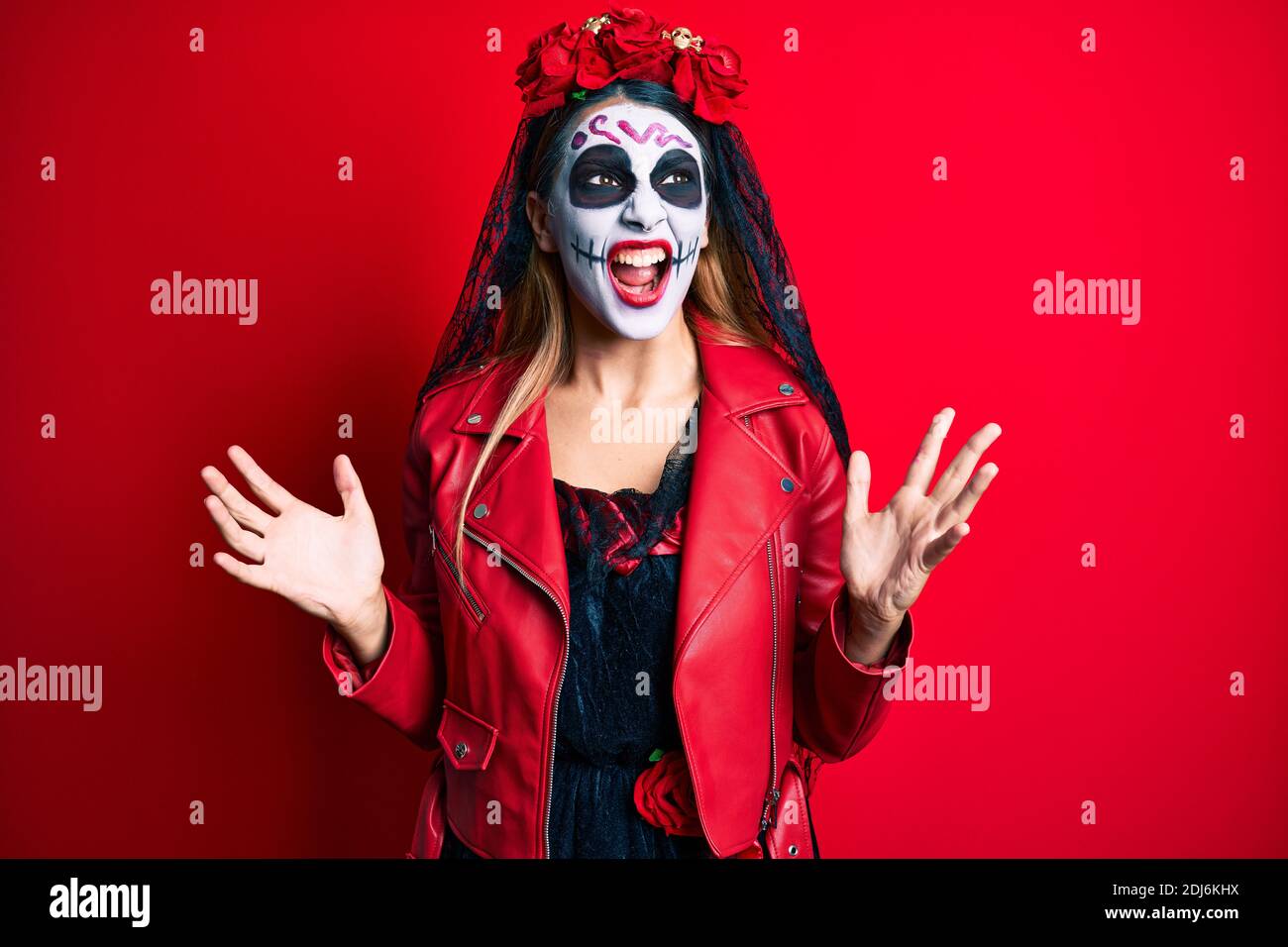 Woman wearing day of the dead costume over red crazy and mad shouting ...