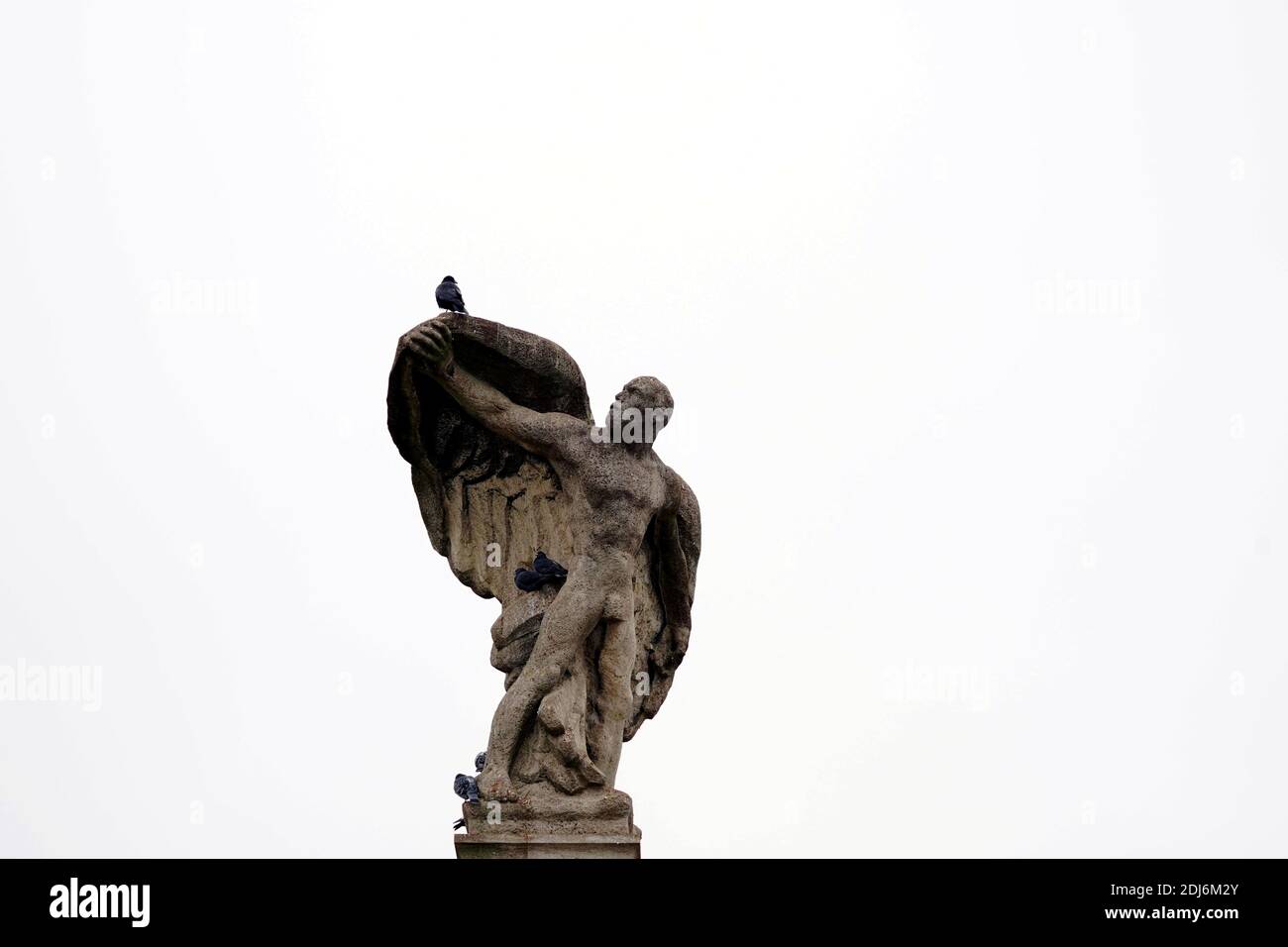 A statue of a man. It seems that he is looking at a raven who landed on ...