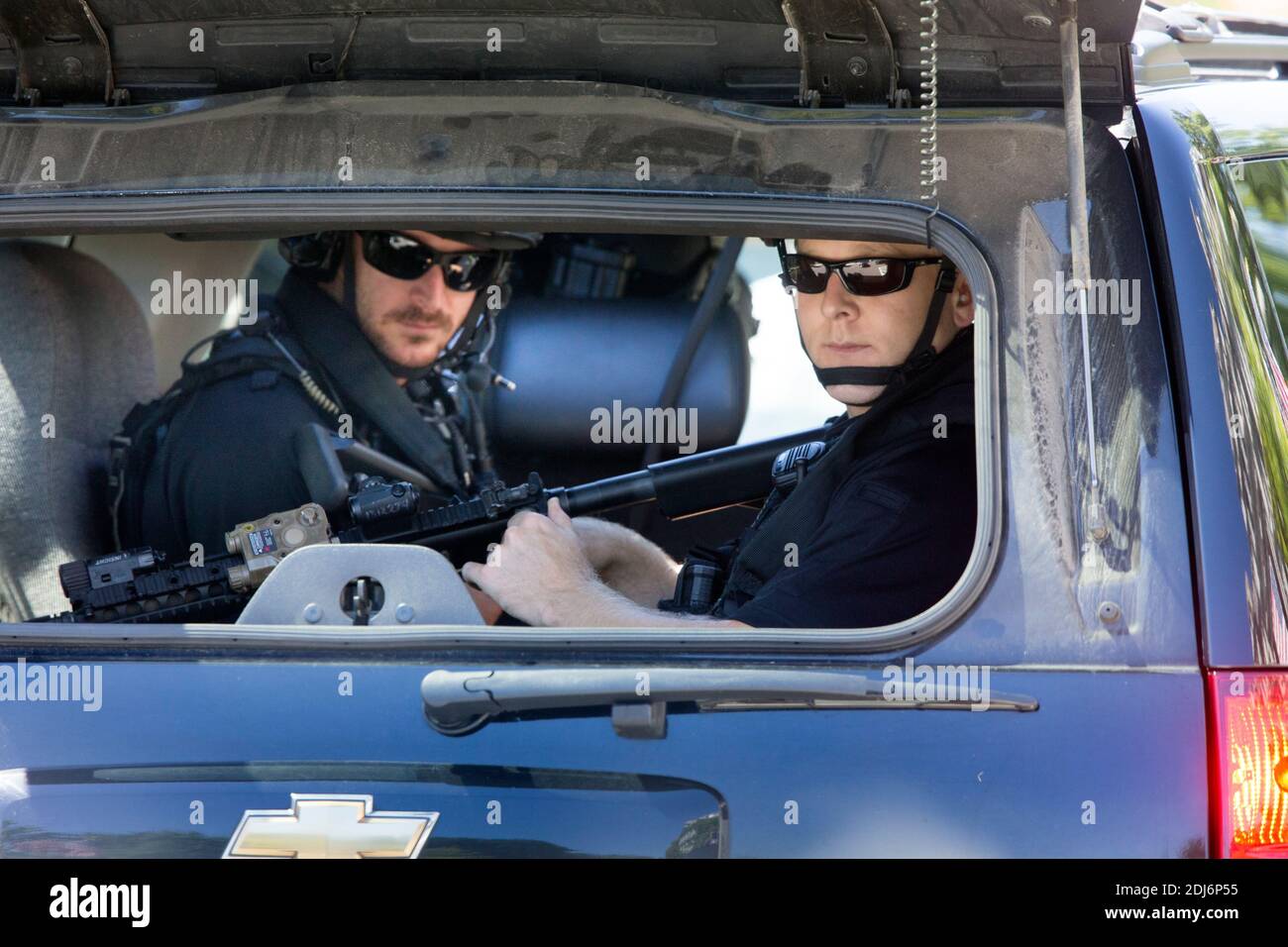 Armed U.S. Secret Service agents sit in the back of a vehicle in the ...