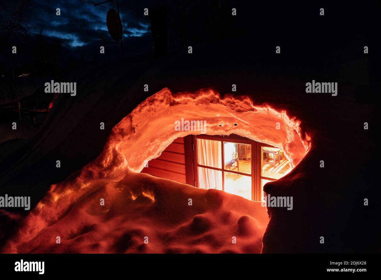 Close up photo of light window of mountain cabin fully buried under ...
