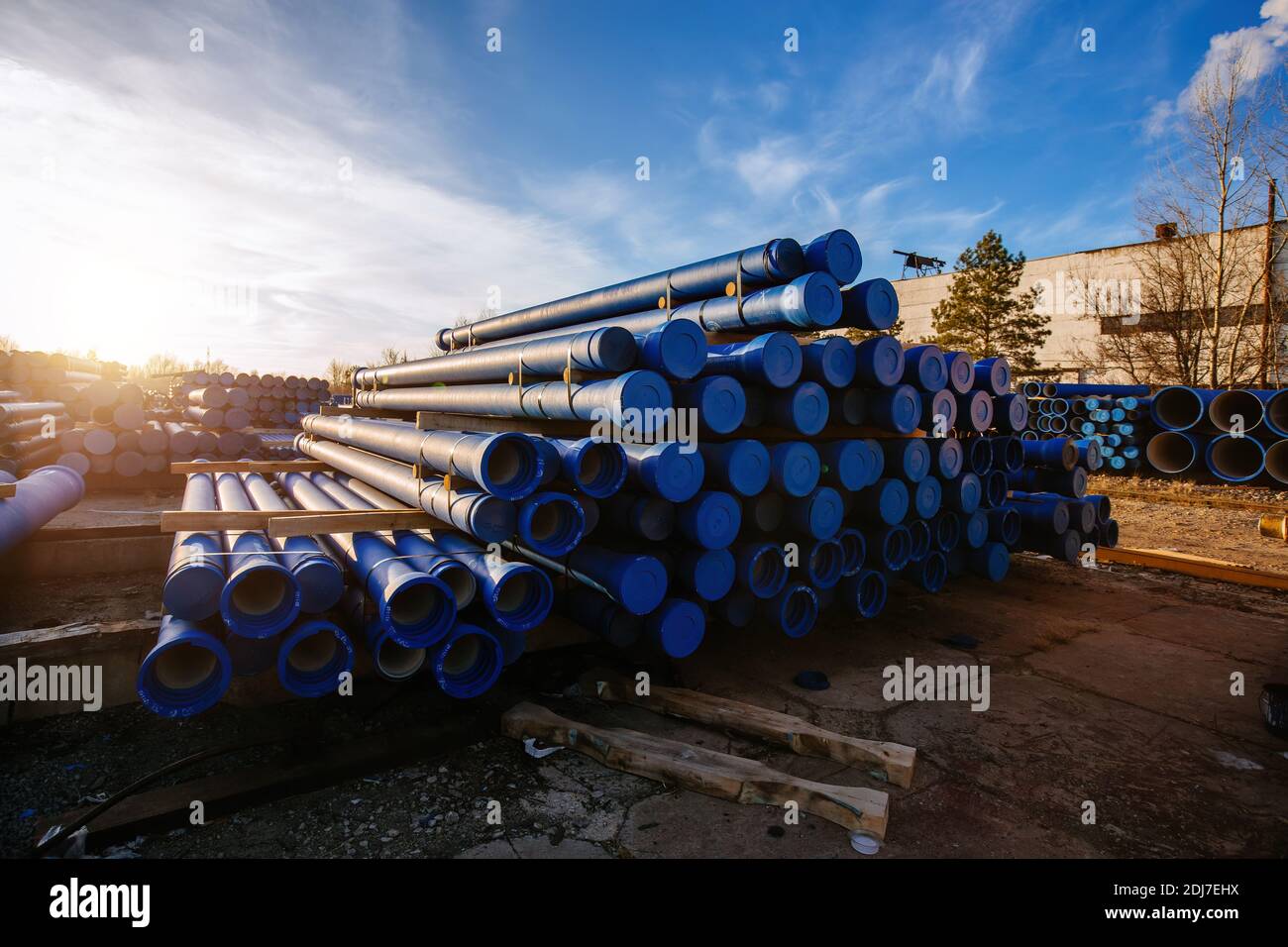 Stack of cast iron pipes in loading area waiting for transportation ...