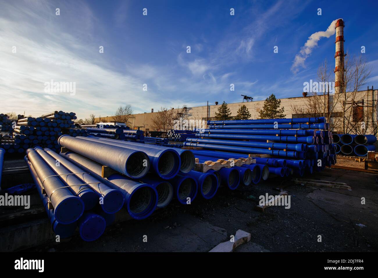 Stack of cast iron pipes in loading area waiting for transportation ...