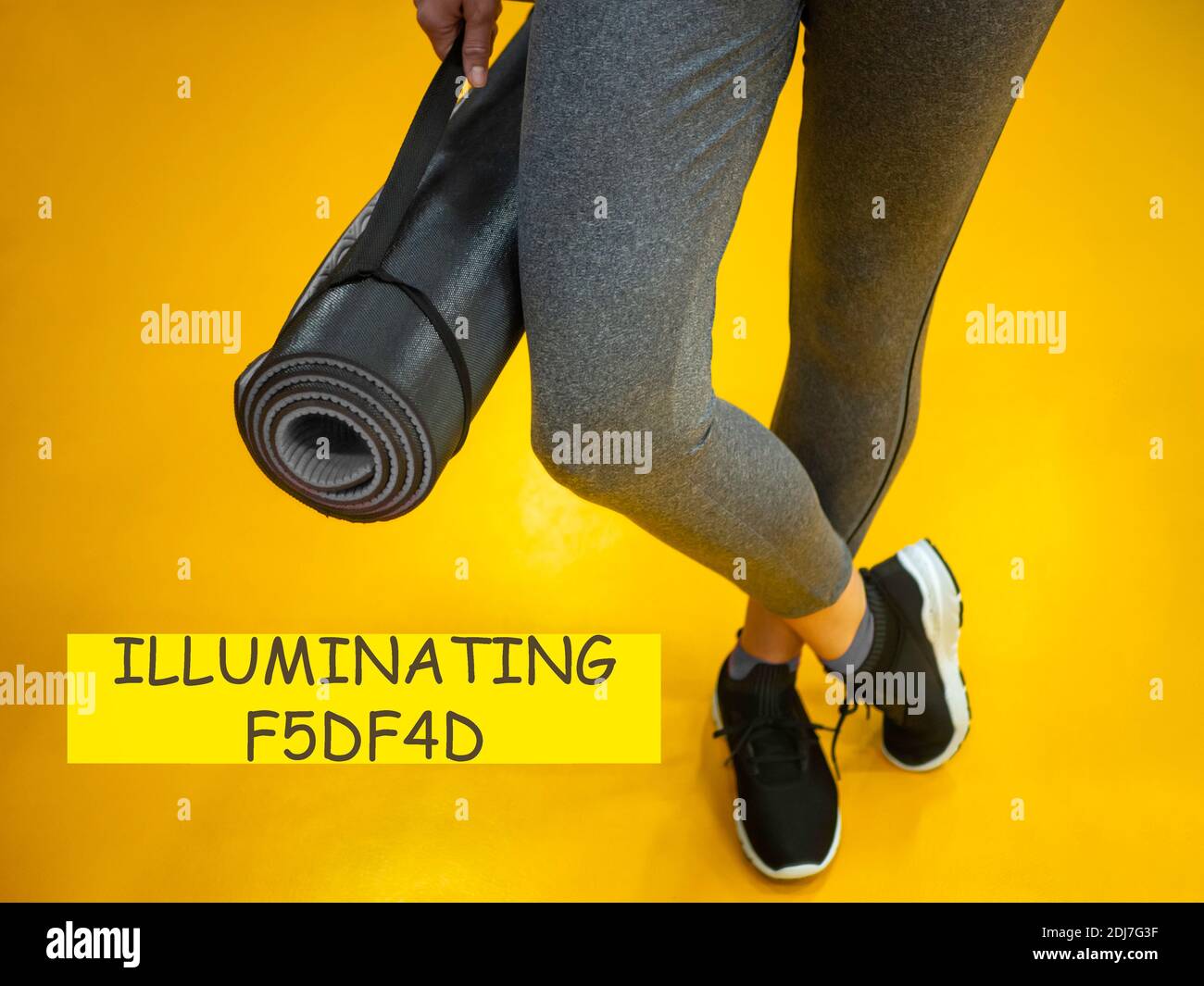 female legs in a sports ultimate gray suit in hand hold mat on ...