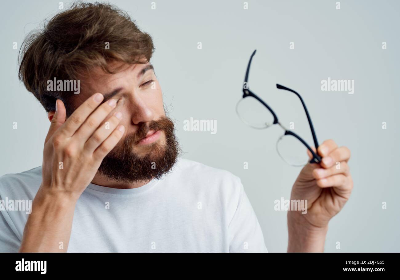 man with glasses in hand on a gray background vision problems eye pain ...