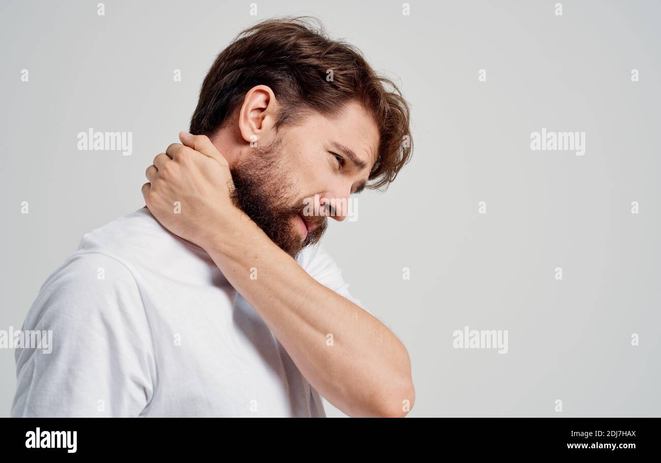 young man touching neck with hands spine pain side view model portrait ...