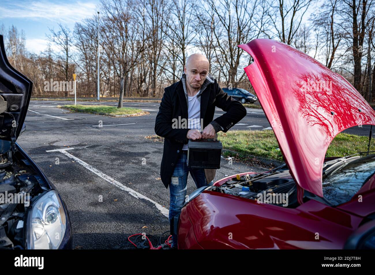 Angry irritated man replacing car battery. Car problem Stock Photo - Alamy