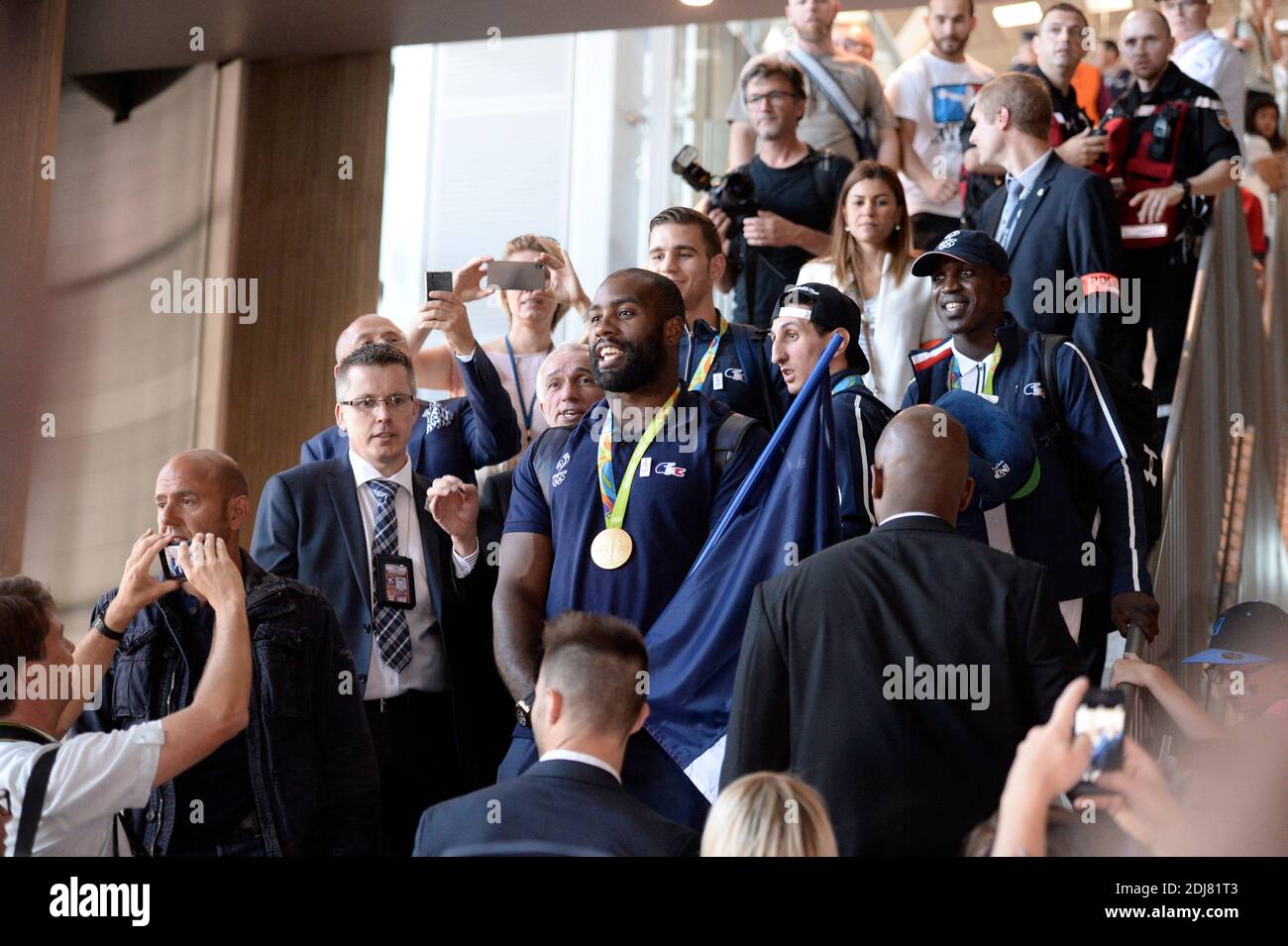 French gold medal winner and judoka Teddy Riner waves a national flag ...