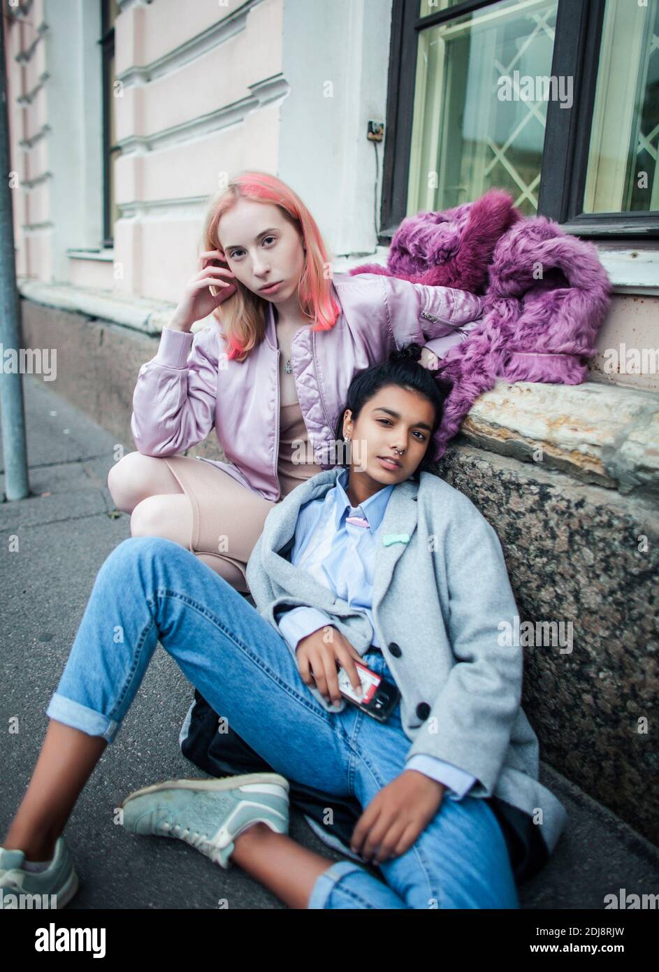 Two teenage girls infront of university building smiling, having fun ...