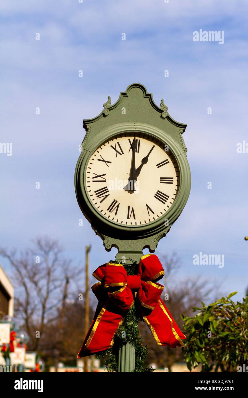 A red ribbon is tied as a Christmas holiday decoration on a green metal ...